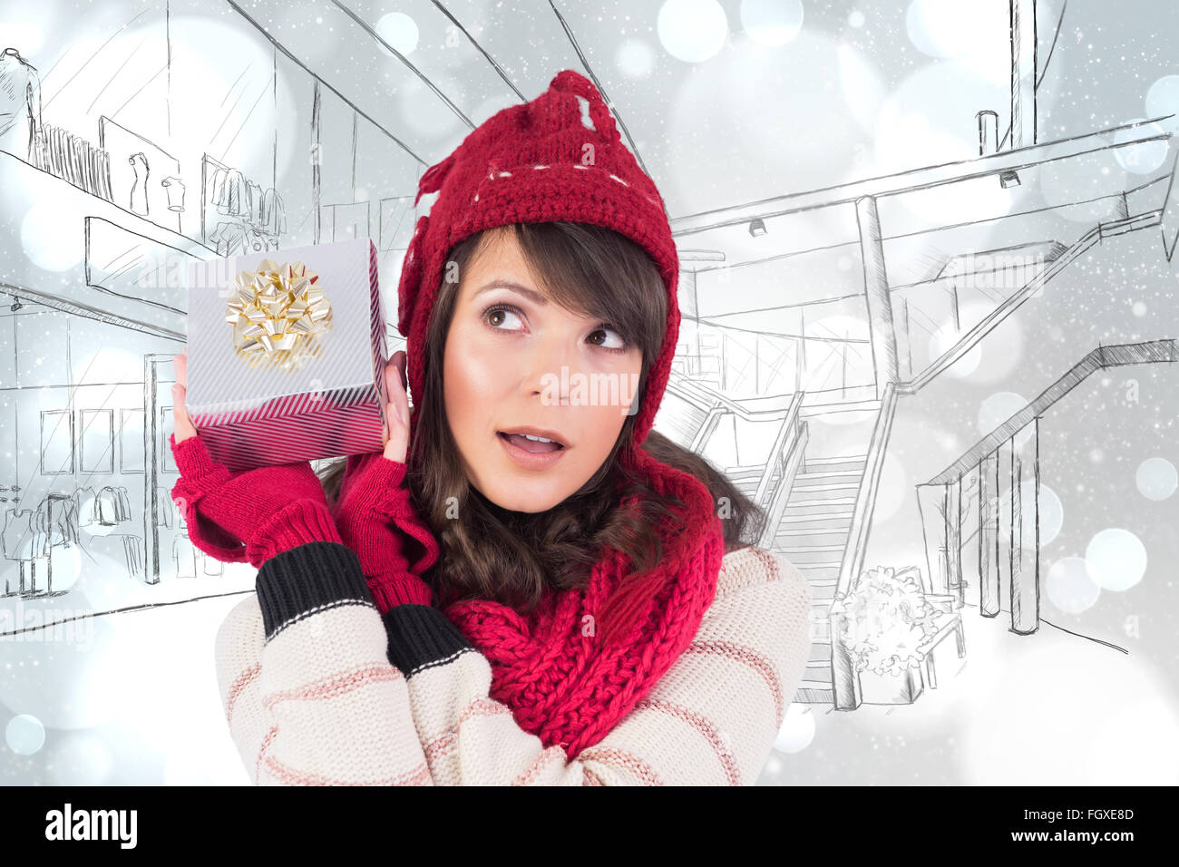 Composite image of young woman shaking her gift in order to guess what ...