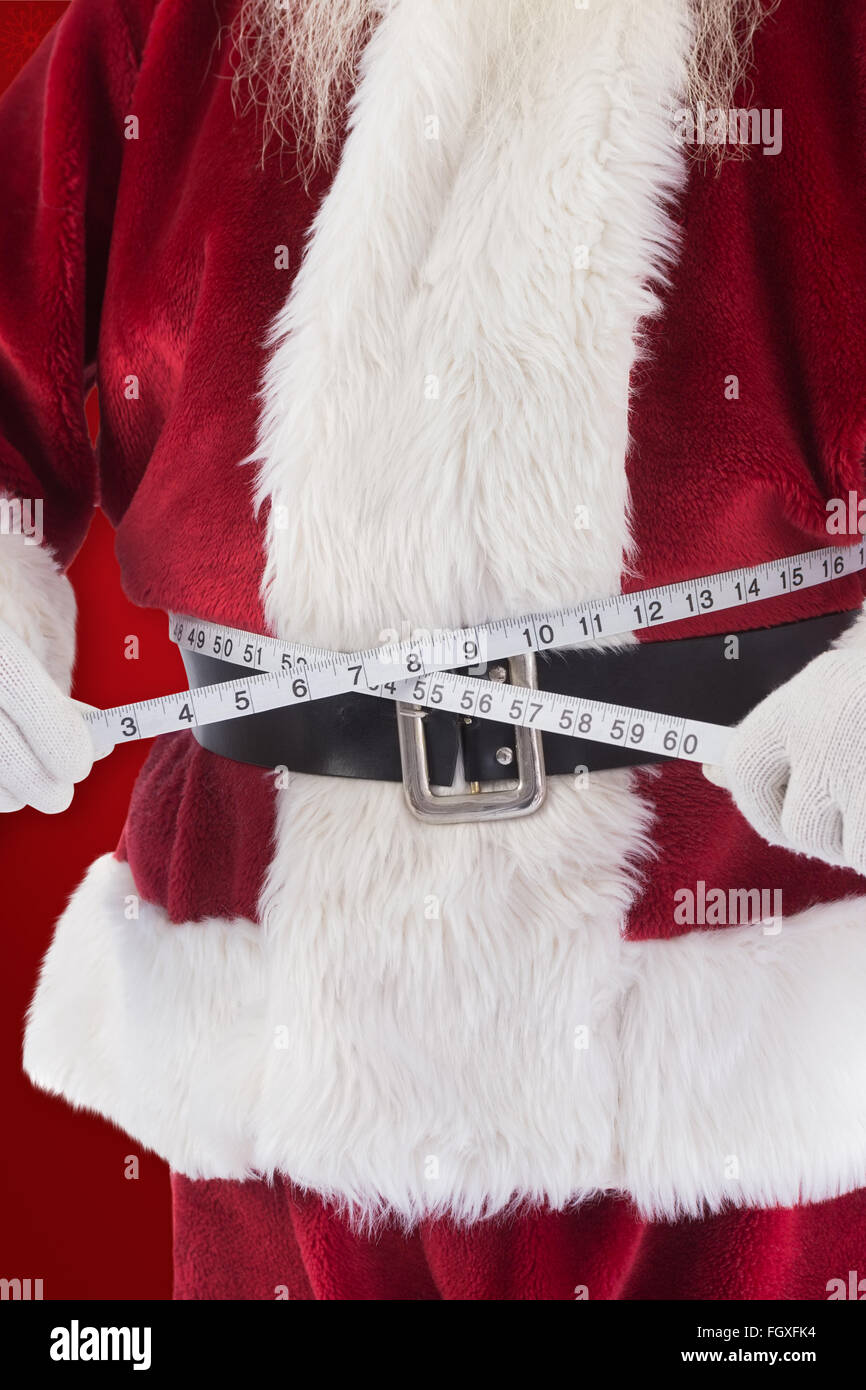 Composite image of santa claus measures his belly Stock Photo - Alamy