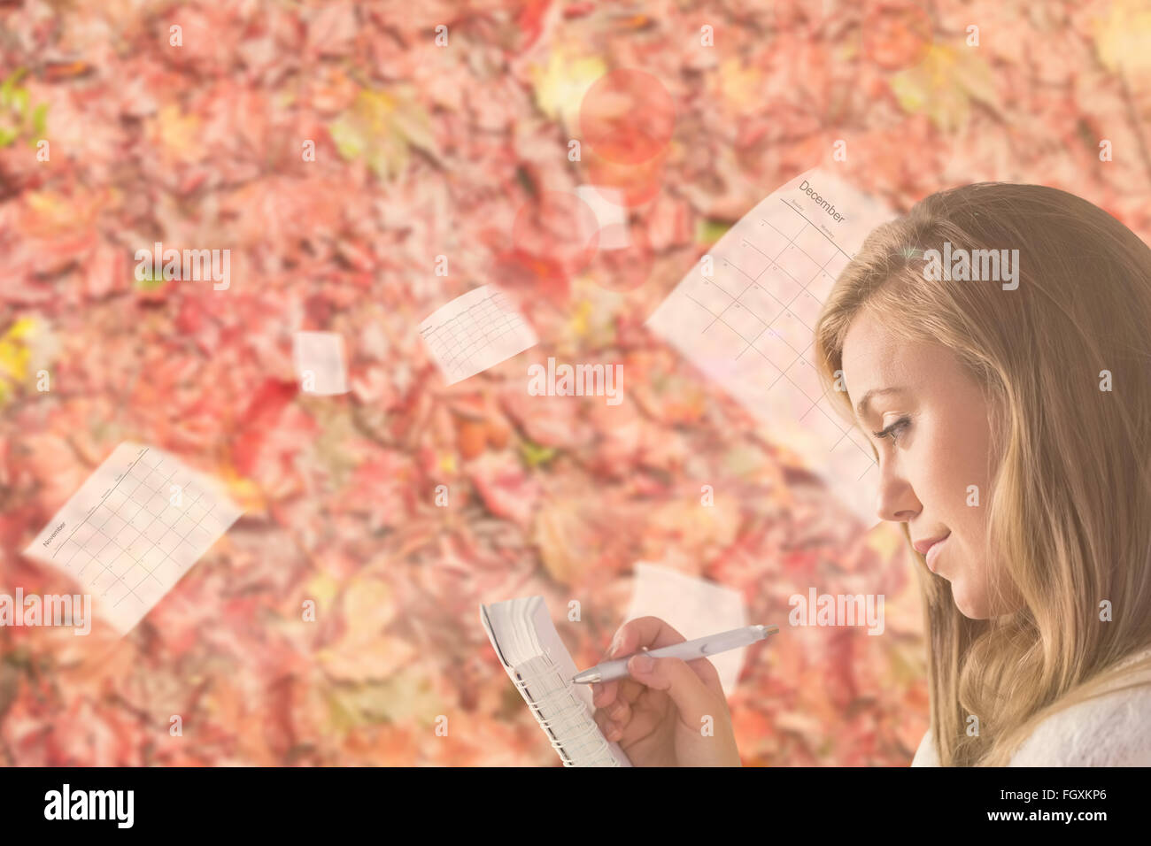 Pretty blonde relaxing on the couch writing in notepad Stock Photo - Alamy