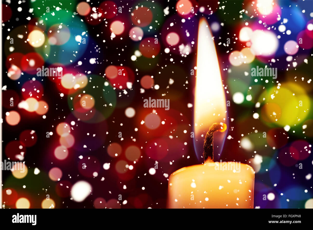 Snow falling against candle burning Stock Photo - Alamy