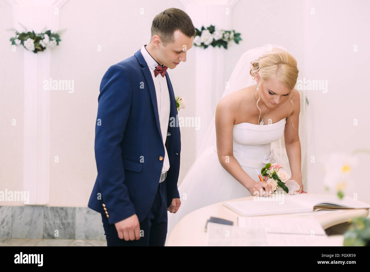 Bride and groom on marriage registration. The groom looks at the bride ...
