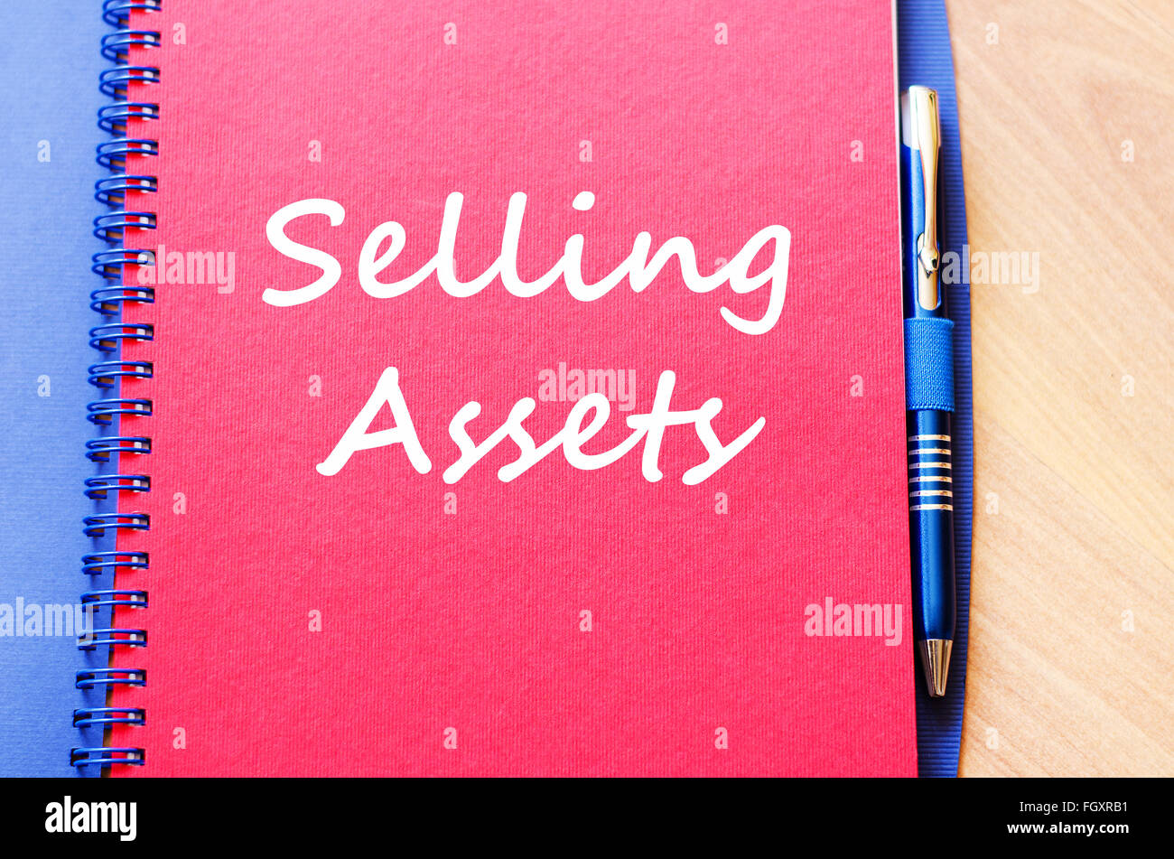 Selling assets text concept write on notebook with pen Stock Photo - Alamy