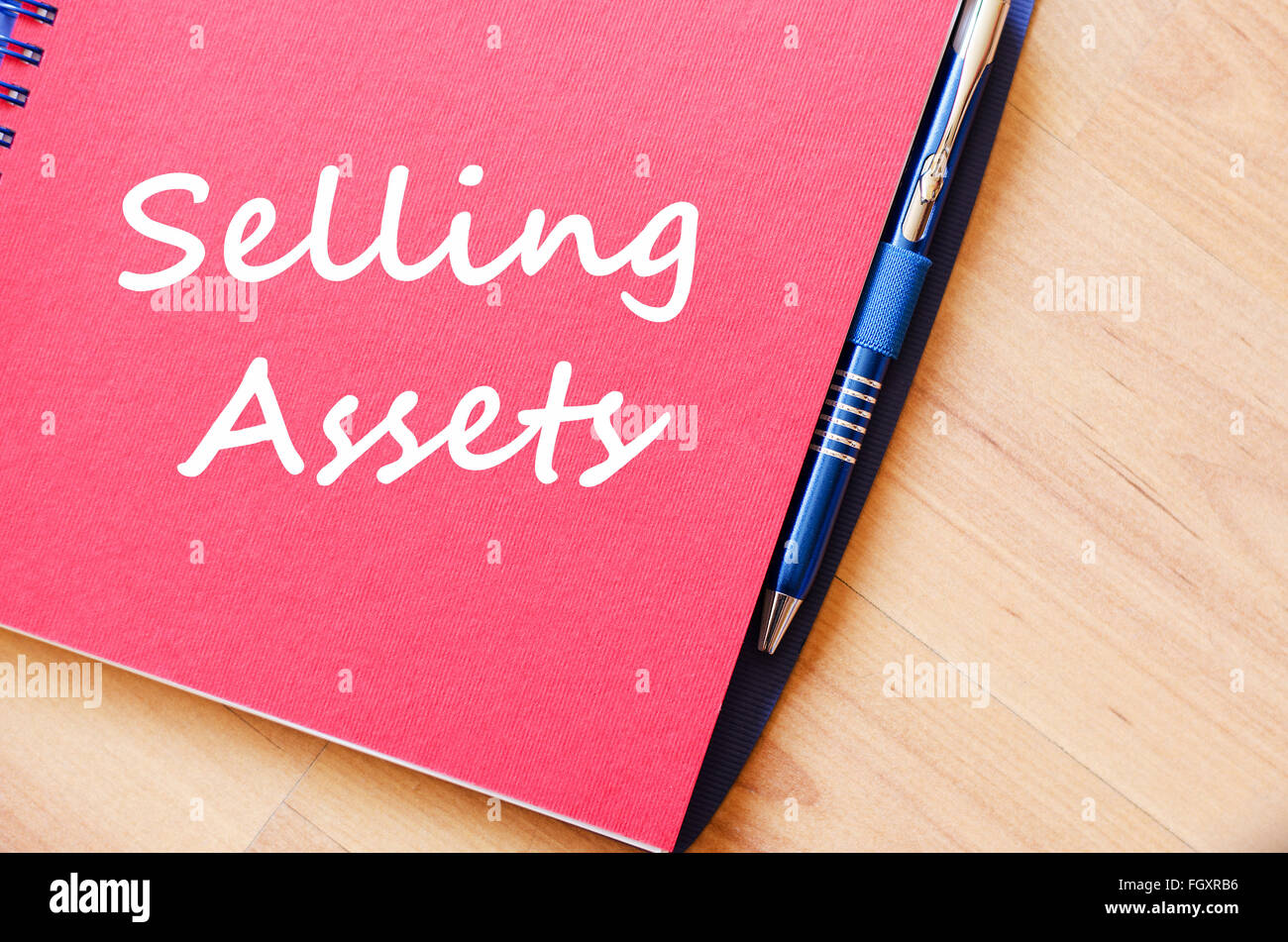 Selling assets text concept write on notebook with pen Stock Photo - Alamy