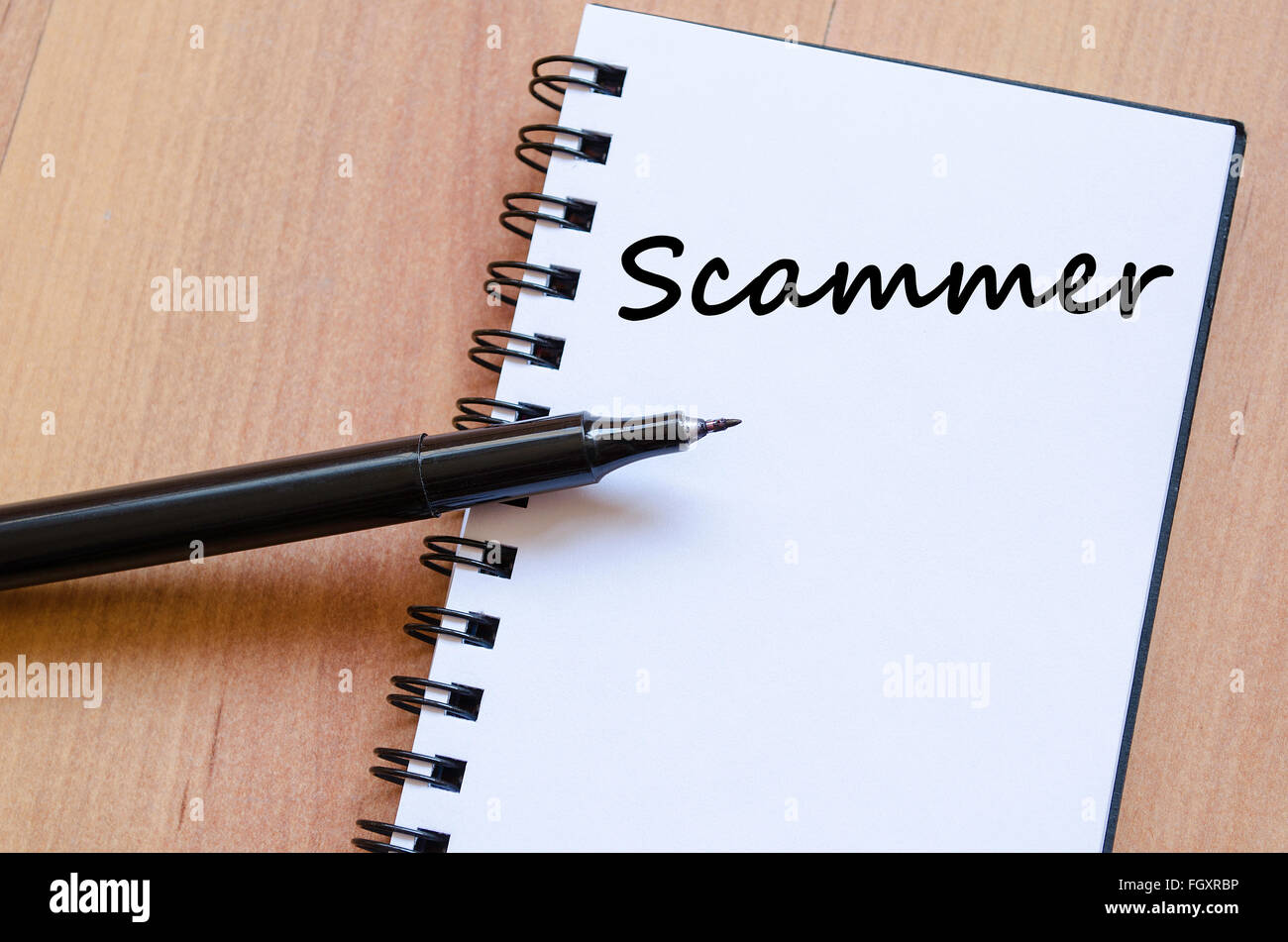 Scammer text concept write on notebook with pen Stock Photo - Alamy