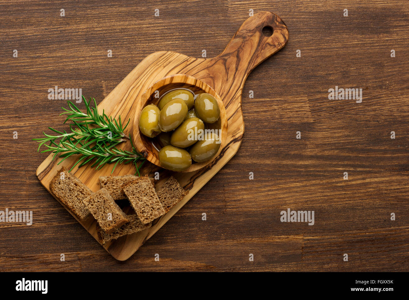 Fresh olives on rustic wooden background with rosmary. Olives in olive ...