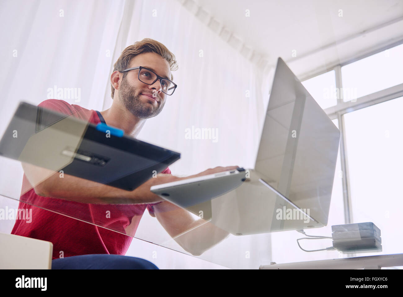 Man at glass desk shot from below Stock Photo - Alamy
