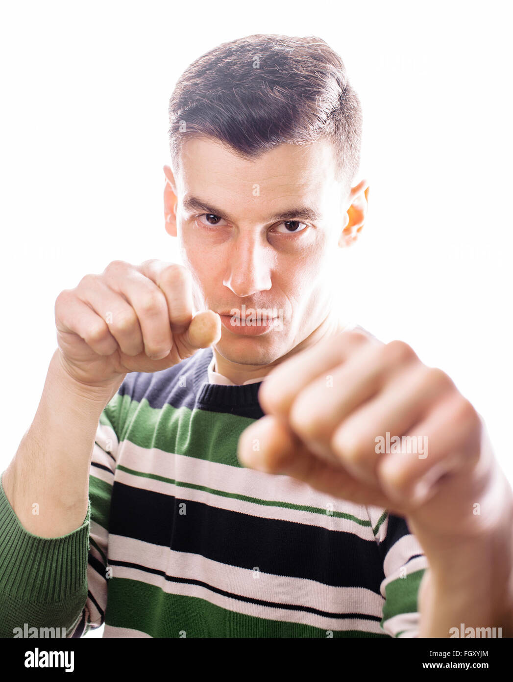 Portrait of a smart serious young man standing against white background ...