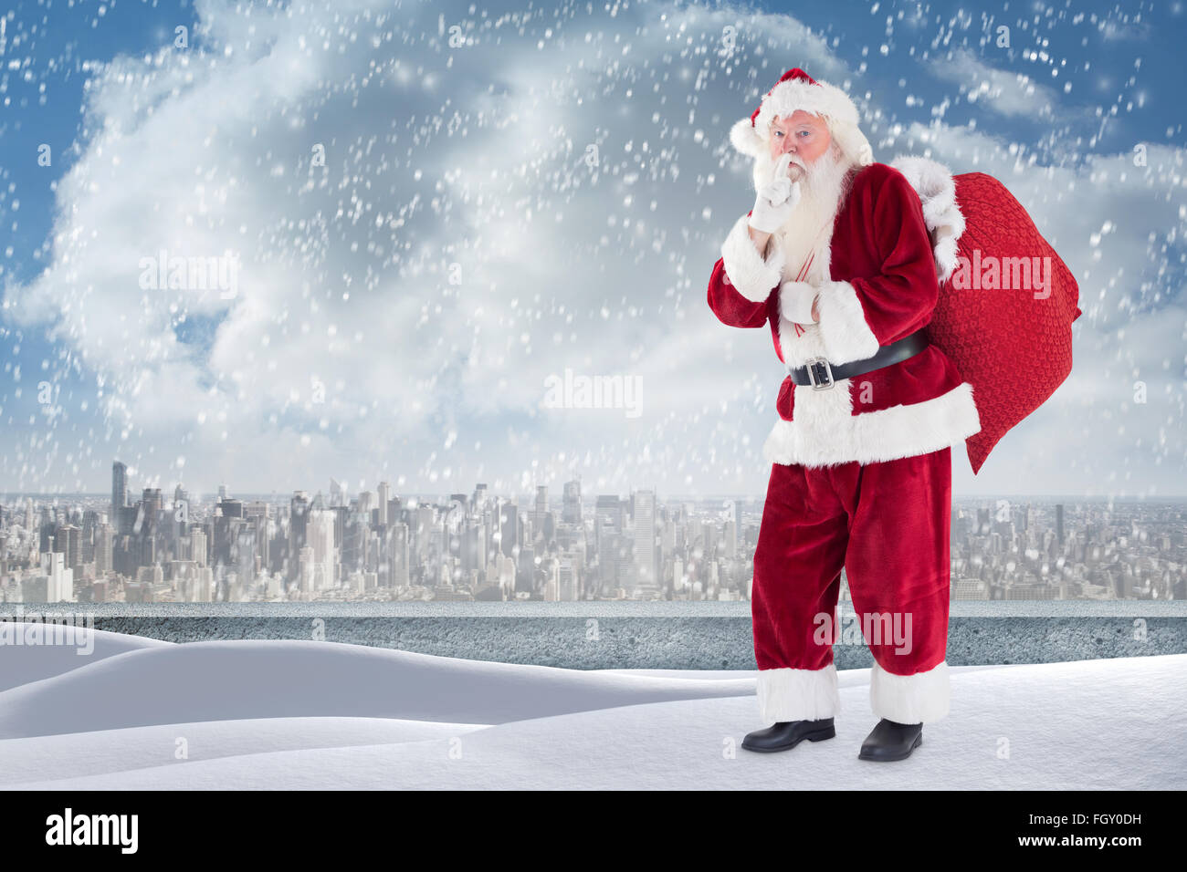Composite image of santa standing on snowy ledge Stock Photo - Alamy