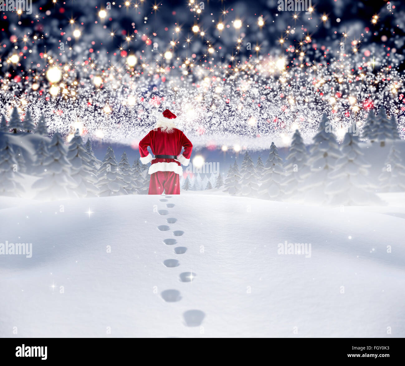 Composite image of santa walking in the snow Stock Photo - Alamy