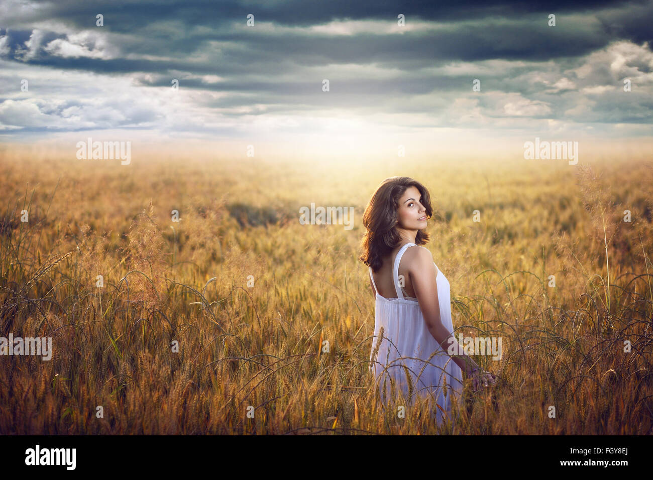 Beautiful woman in a corn field with dramatic sky . Sunset light Stock ...