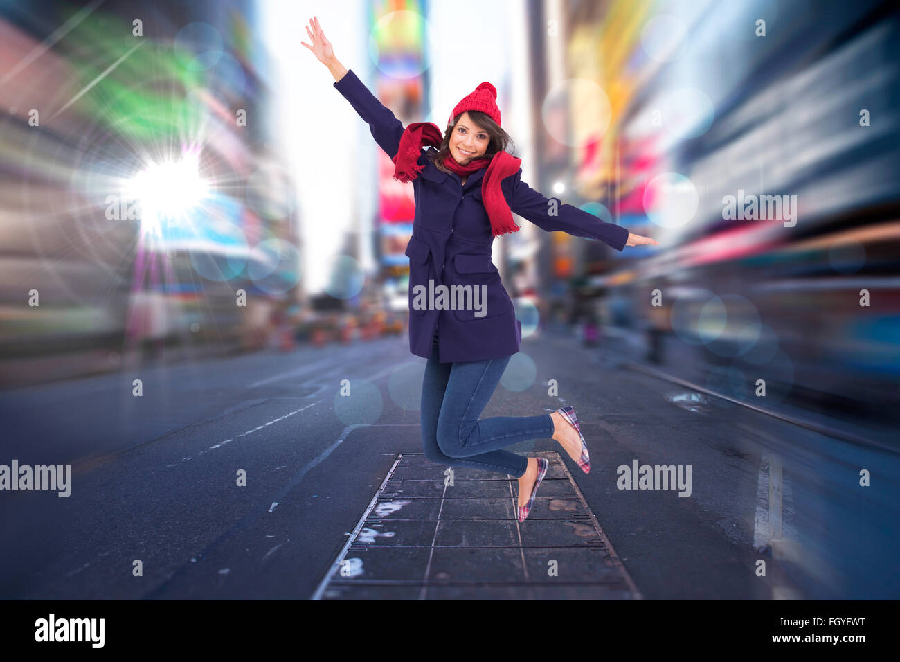 Composite image of woman in warm clothing jumping Stock Photo - Alamy