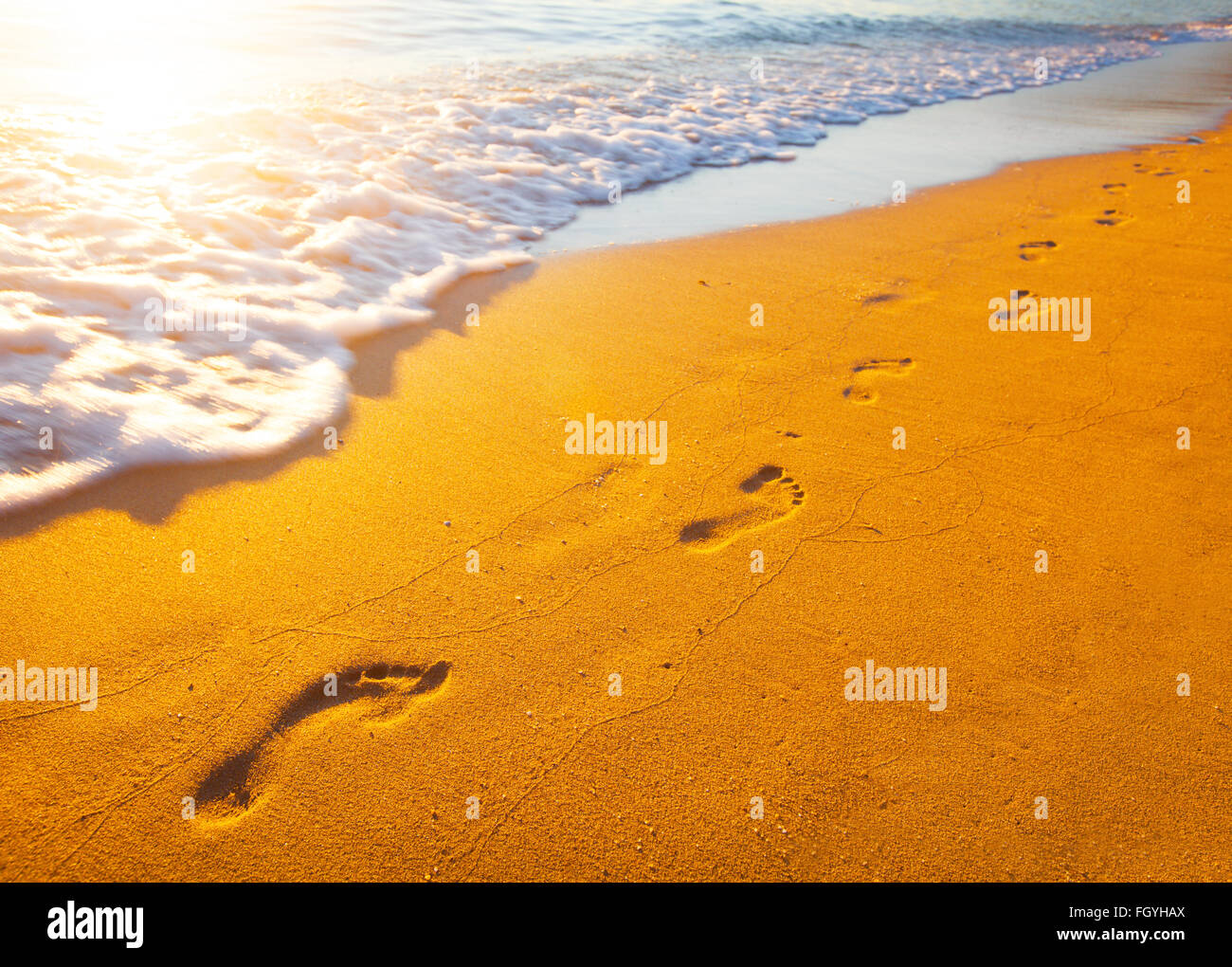 beach, wave and footprints at sunset time Stock Photo - Alamy