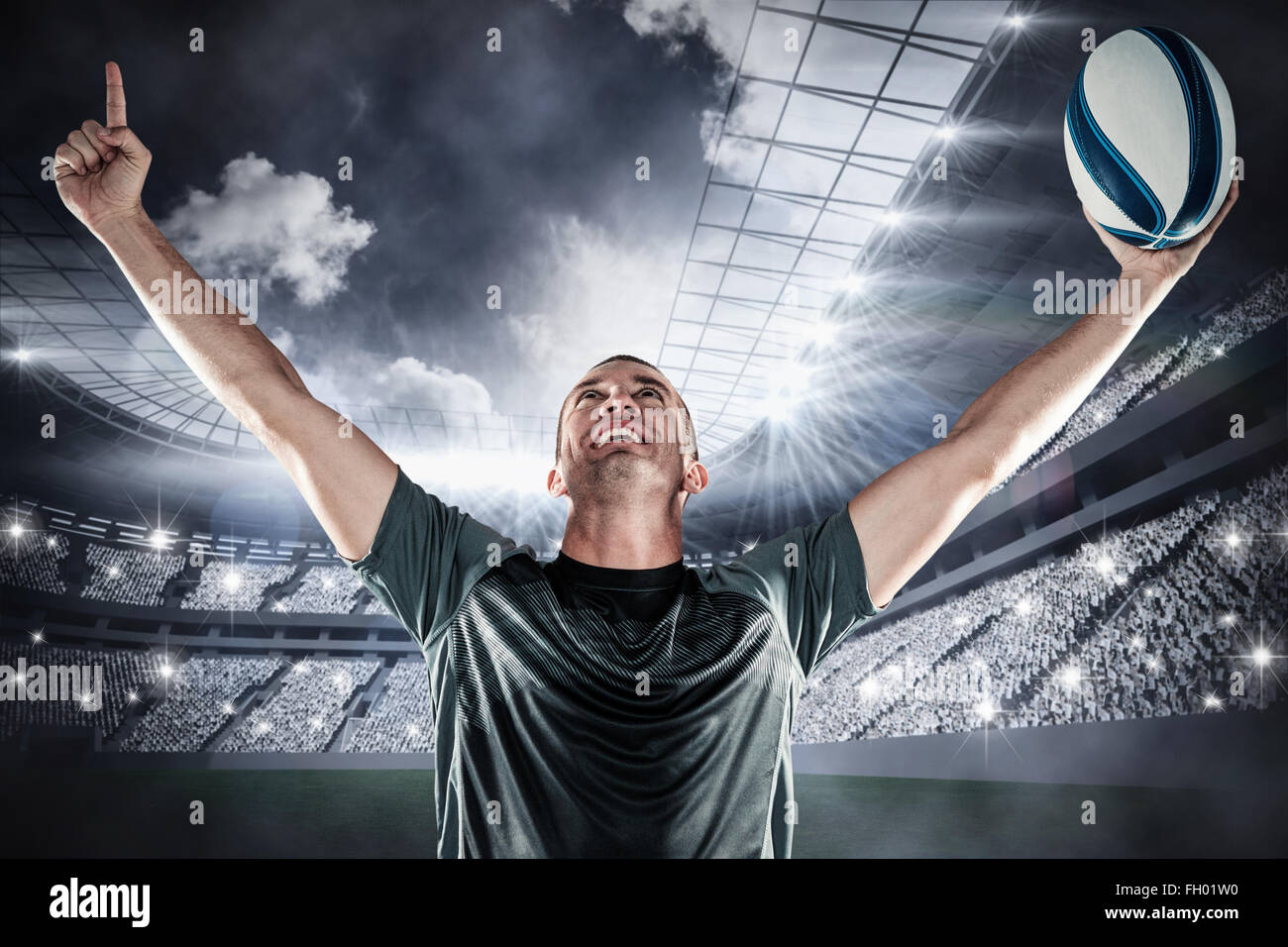 Composite image of successful rugby player holding ball with arms ...