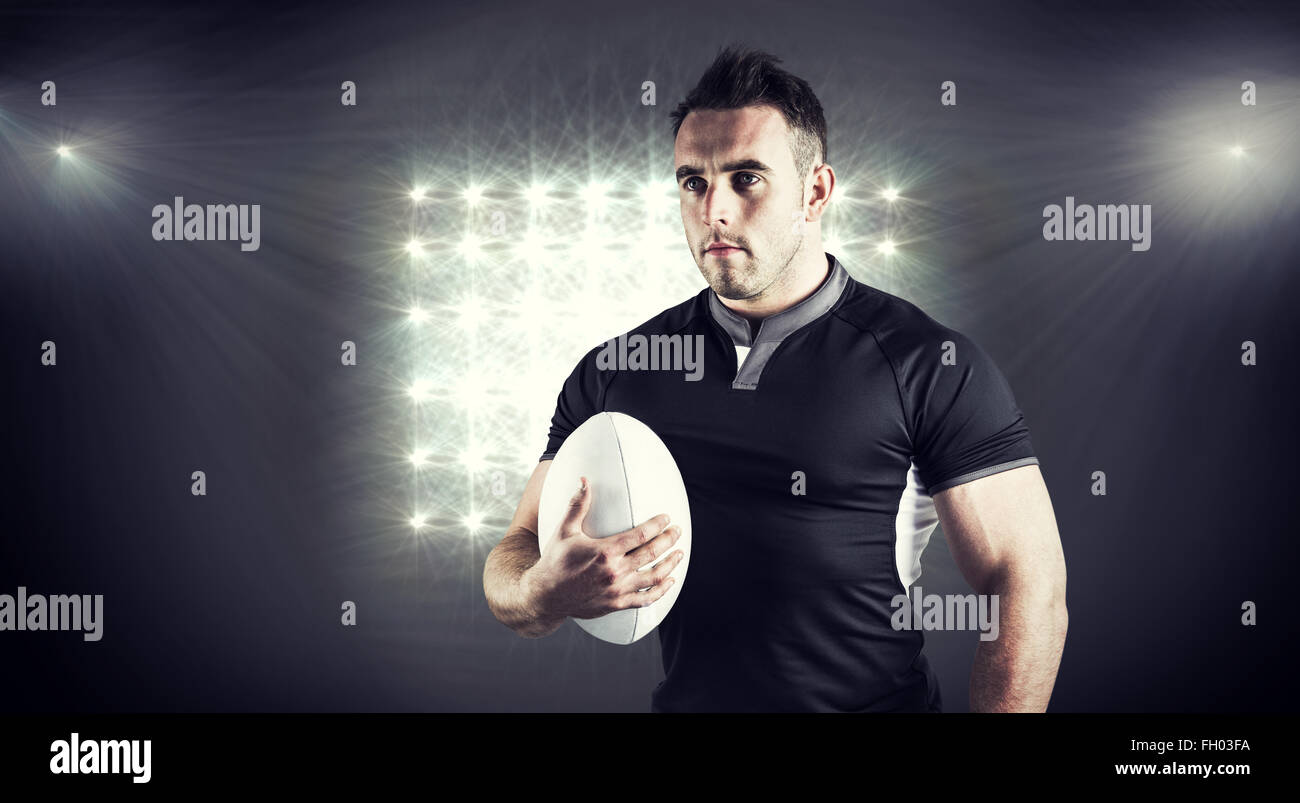 Composite image of tough rugby player holding ball Stock Photo - Alamy