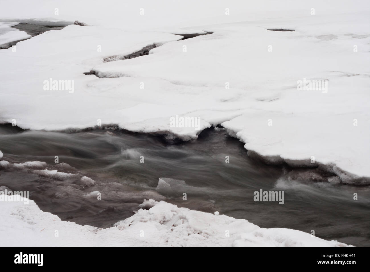 Stream flowing through chunks of ice in the winter Stock Photo - Alamy