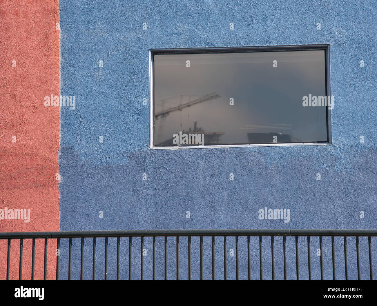 Blue and red wall with window showing reflection Stock Photo - Alamy
