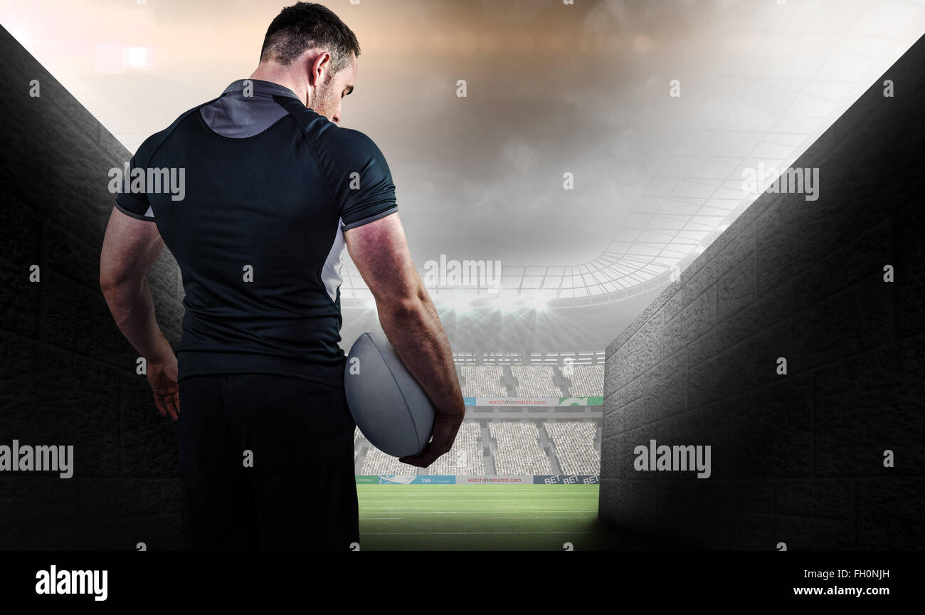 Composite image of tough rugby player holding ball Stock Photo - Alamy