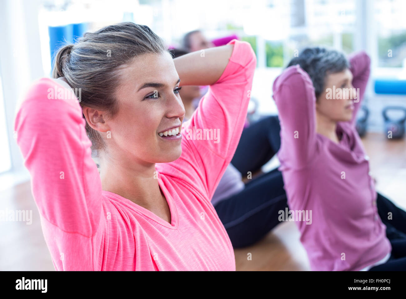 Fit women doing sit ups on hardwood floor Stock Photo - Alamy