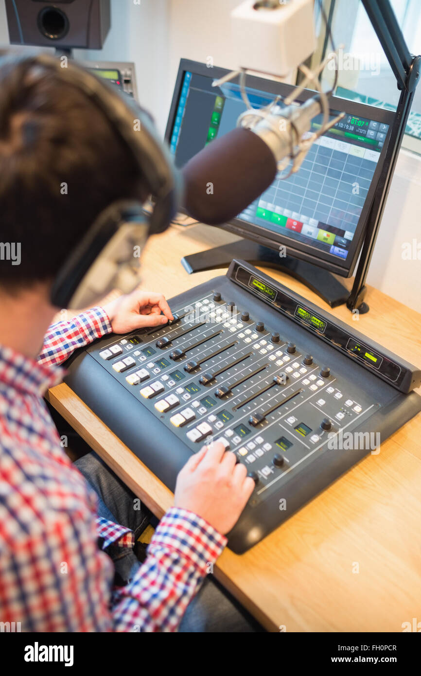 Radio host using sound mixer on table Stock Photo - Alamy
