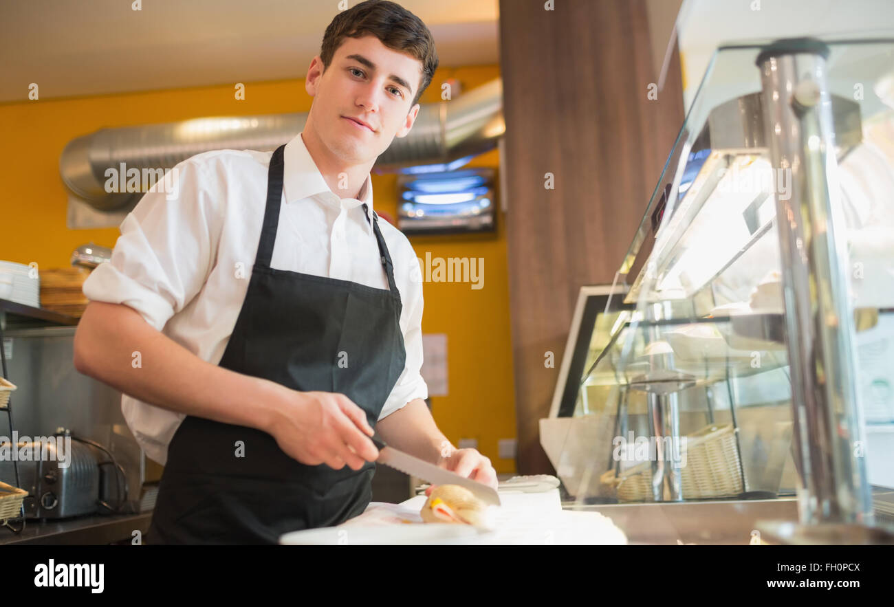 Male worker cutting sandwich on counter Stock Photo - Alamy