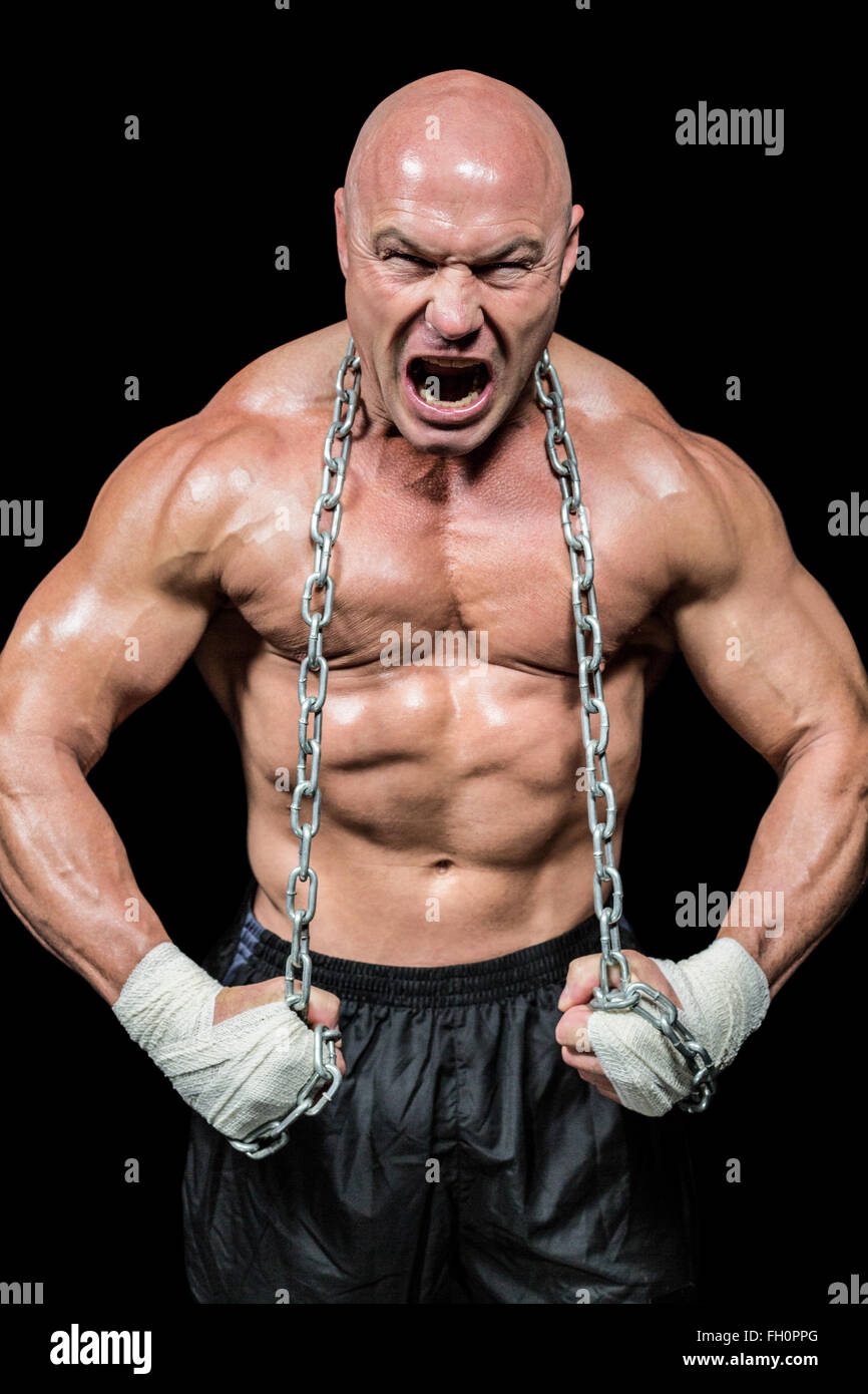 Aggressive muscular man flexing muscle while holding chain Stock Photo ...