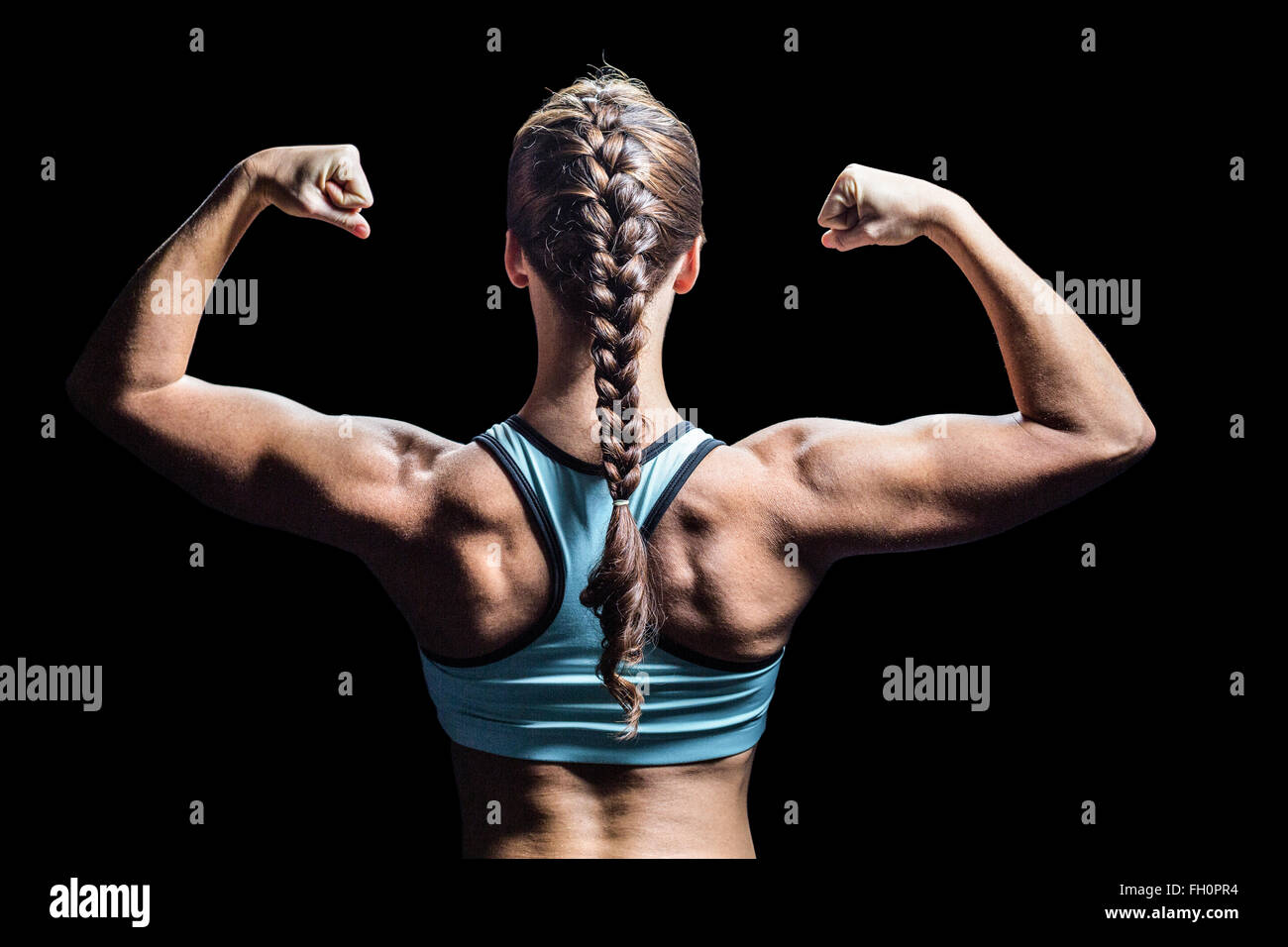 Rear view of woman with braided hair flexing muscles Stock Photo - Alamy