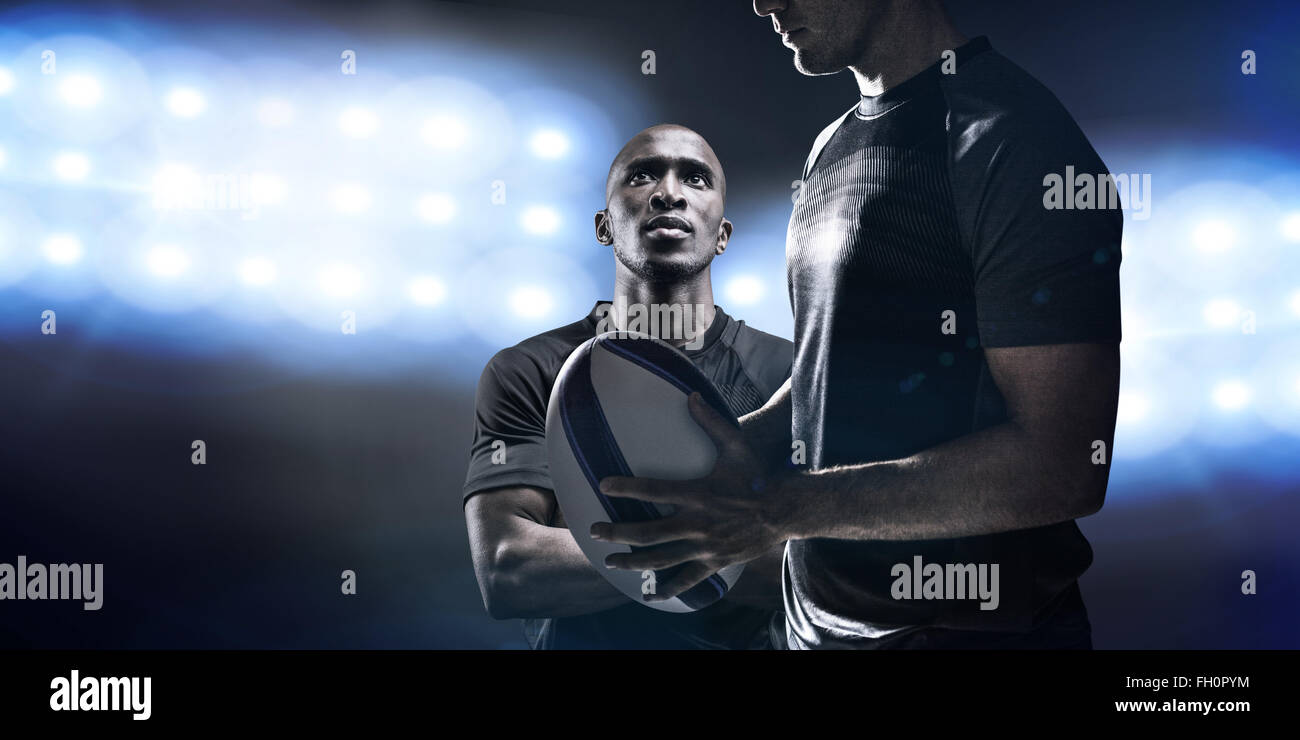 Composite image of calm rugby player thinking while holding ball Stock ...