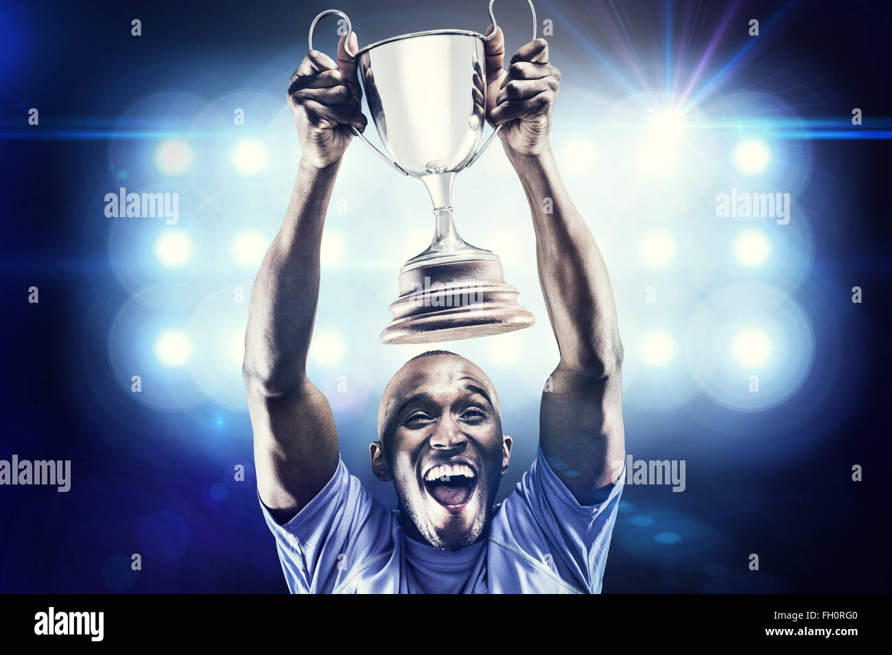 Composite image of happy athlete cheering while holding trophy Stock ...