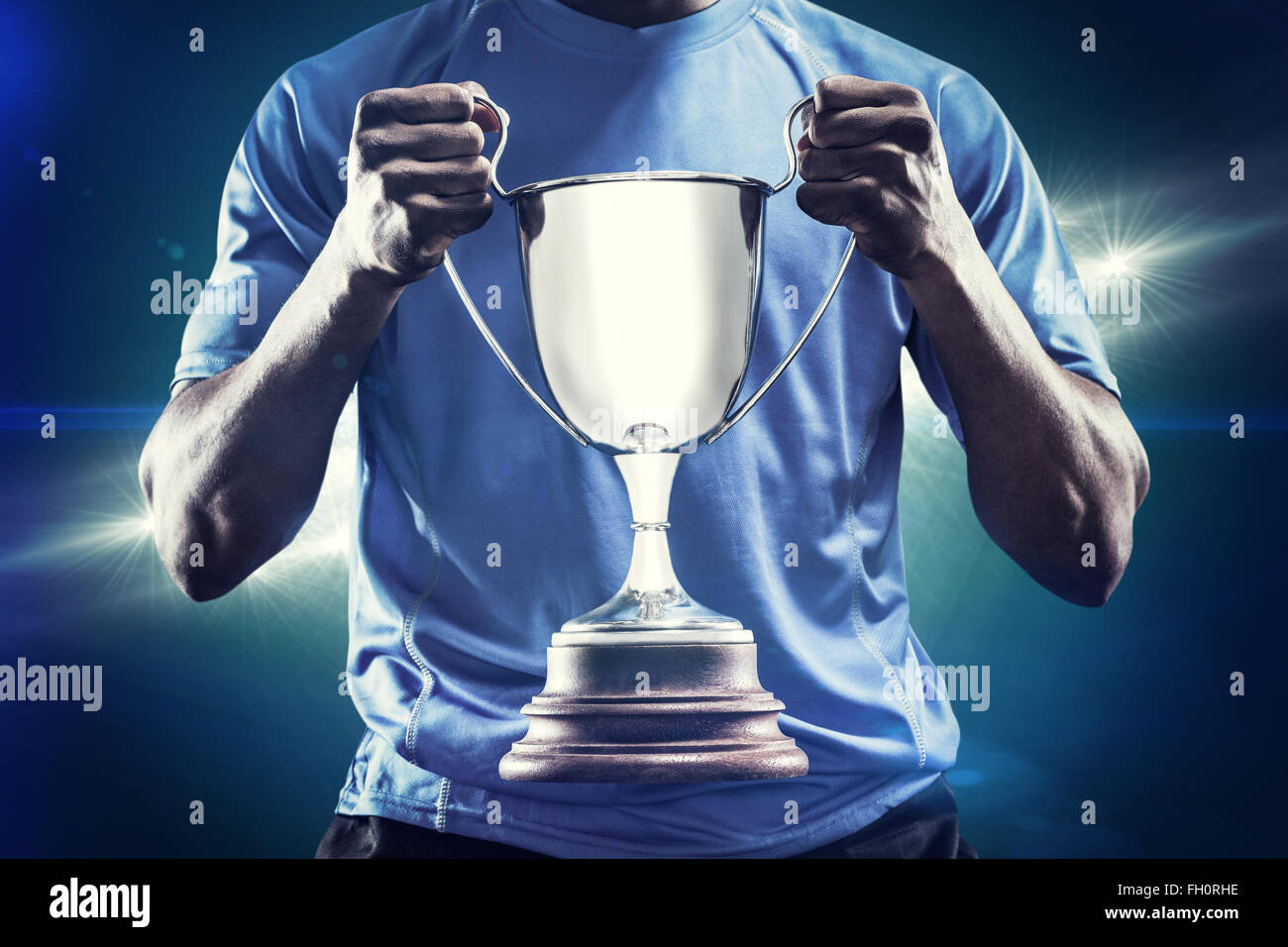 Composite image of mid section of sportsman holding trophy Stock Photo ...