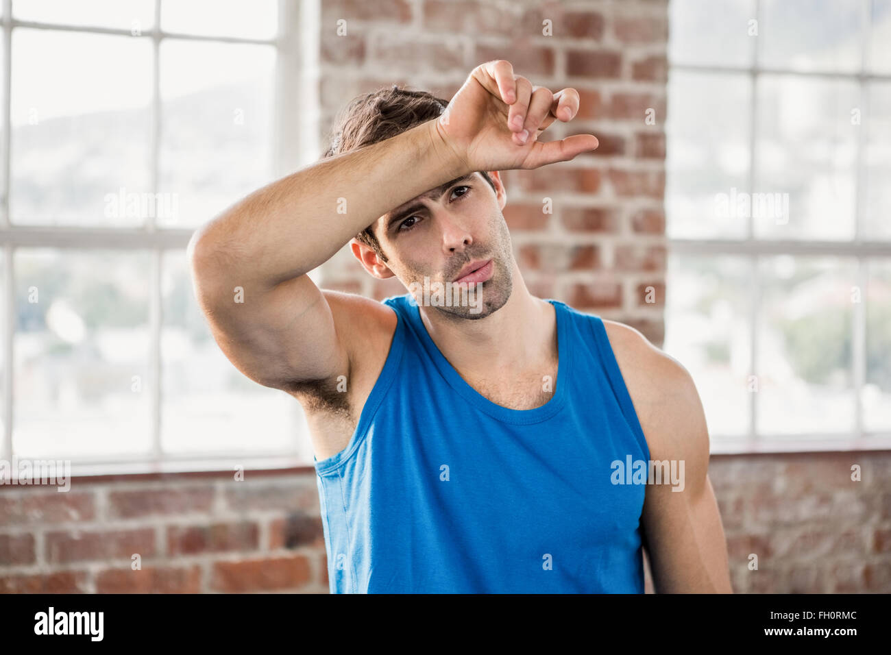 Man wiping his forehead with arm Stock Photo - Alamy