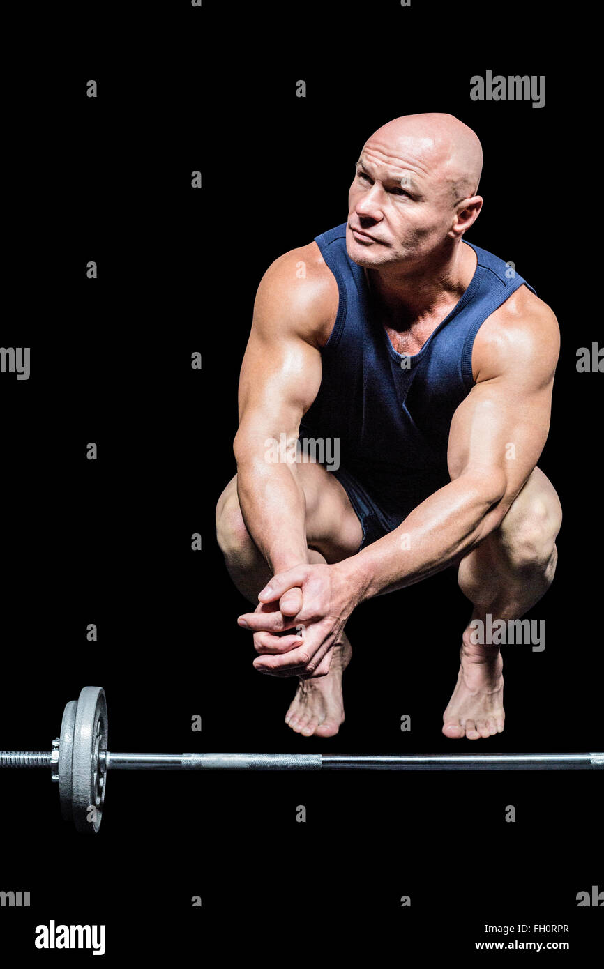 Bodybuilder crouching by crossfit Stock Photo - Alamy