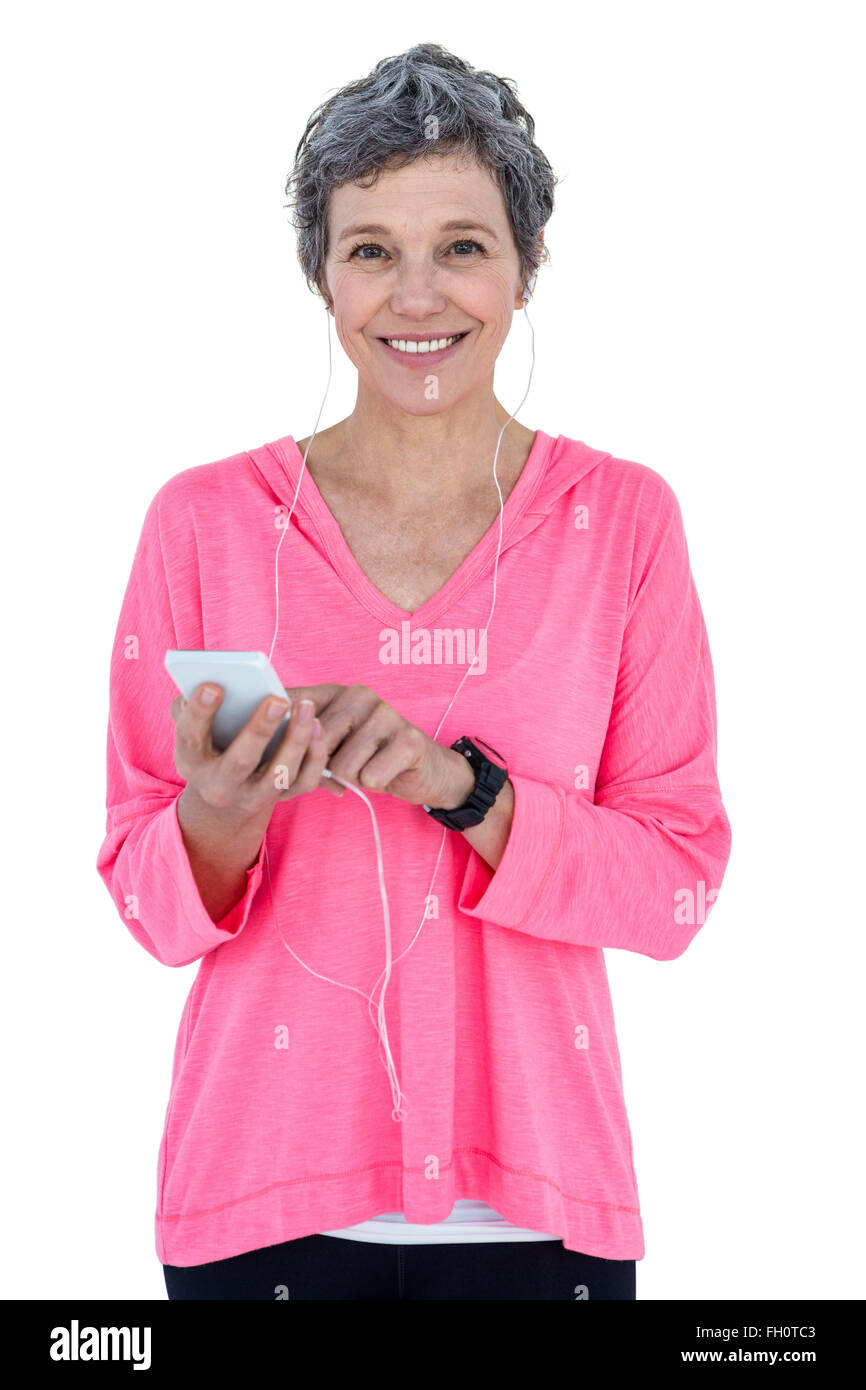 Happy woman using mobile phone while listening music Stock Photo - Alamy