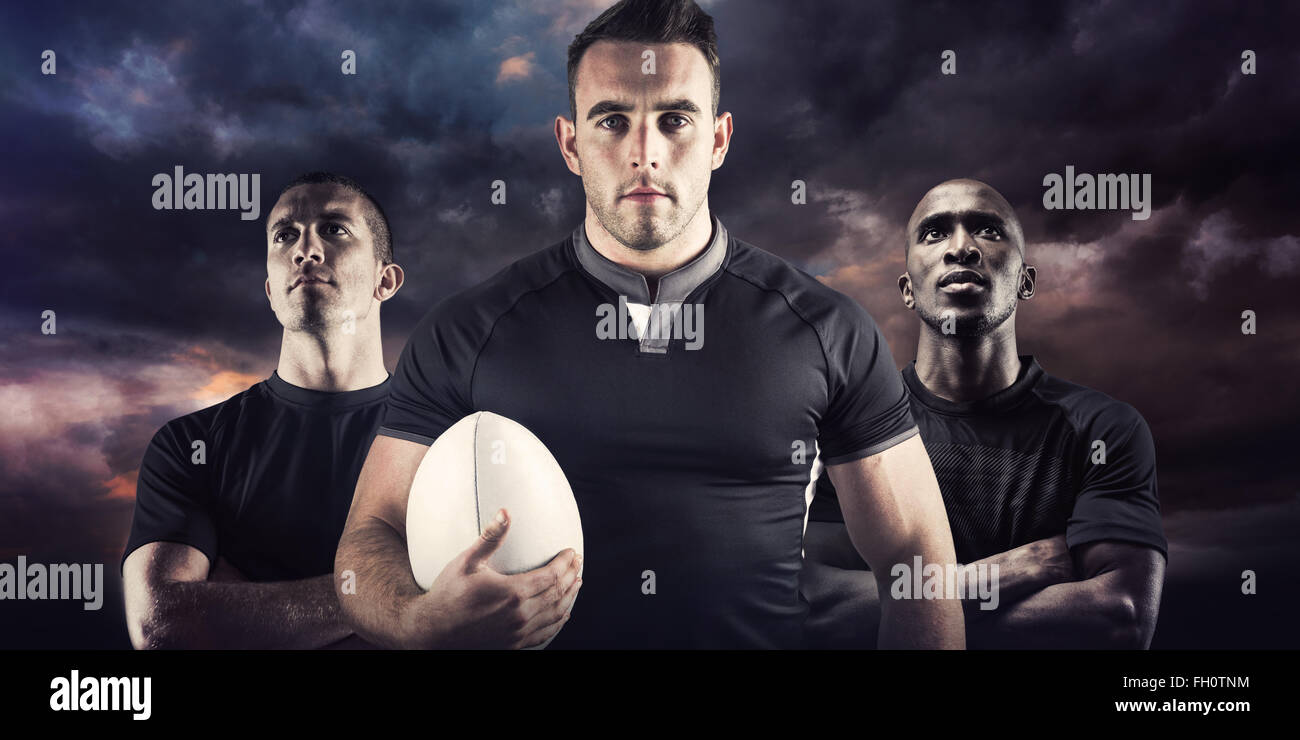 Composite image of tough rugby player holding ball Stock Photo - Alamy