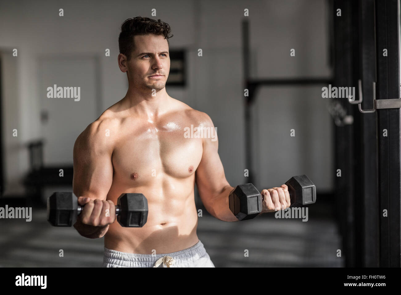 Muscular serious man doing weightlifting Stock Photo - Alamy
