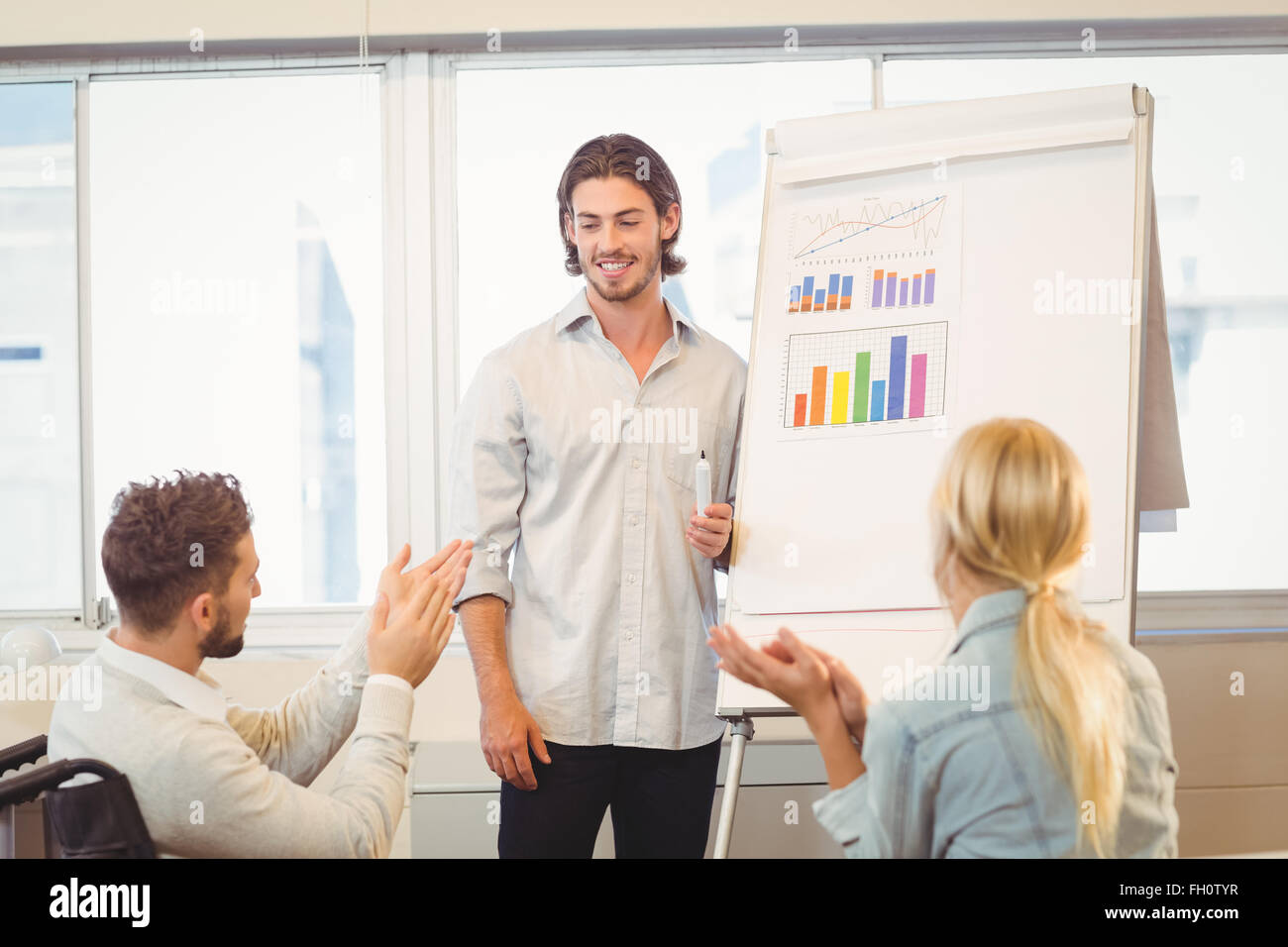 Business people clapping for male colleague Stock Photo - Alamy
