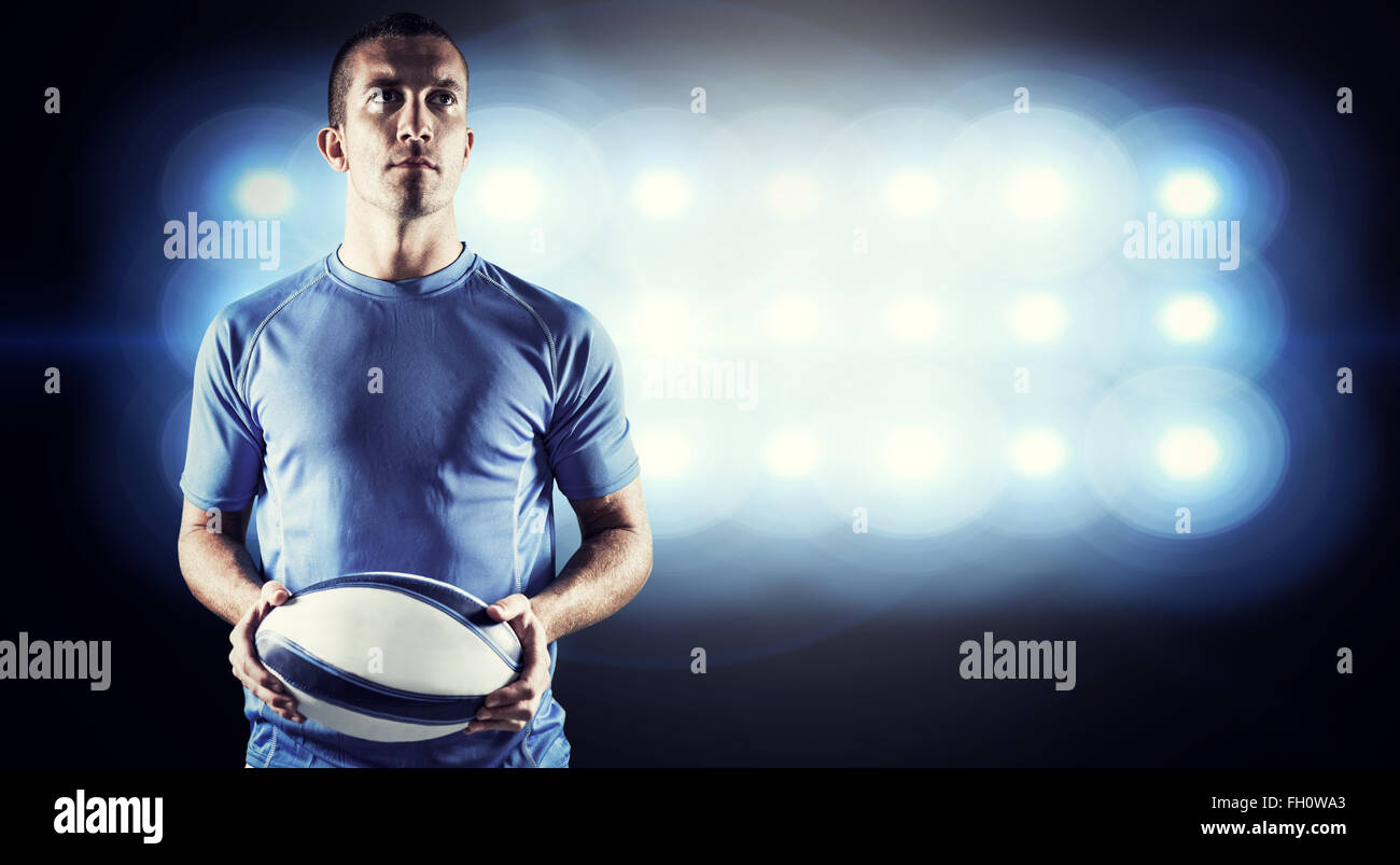 Composite image of confident rugby player holding ball Stock Photo - Alamy
