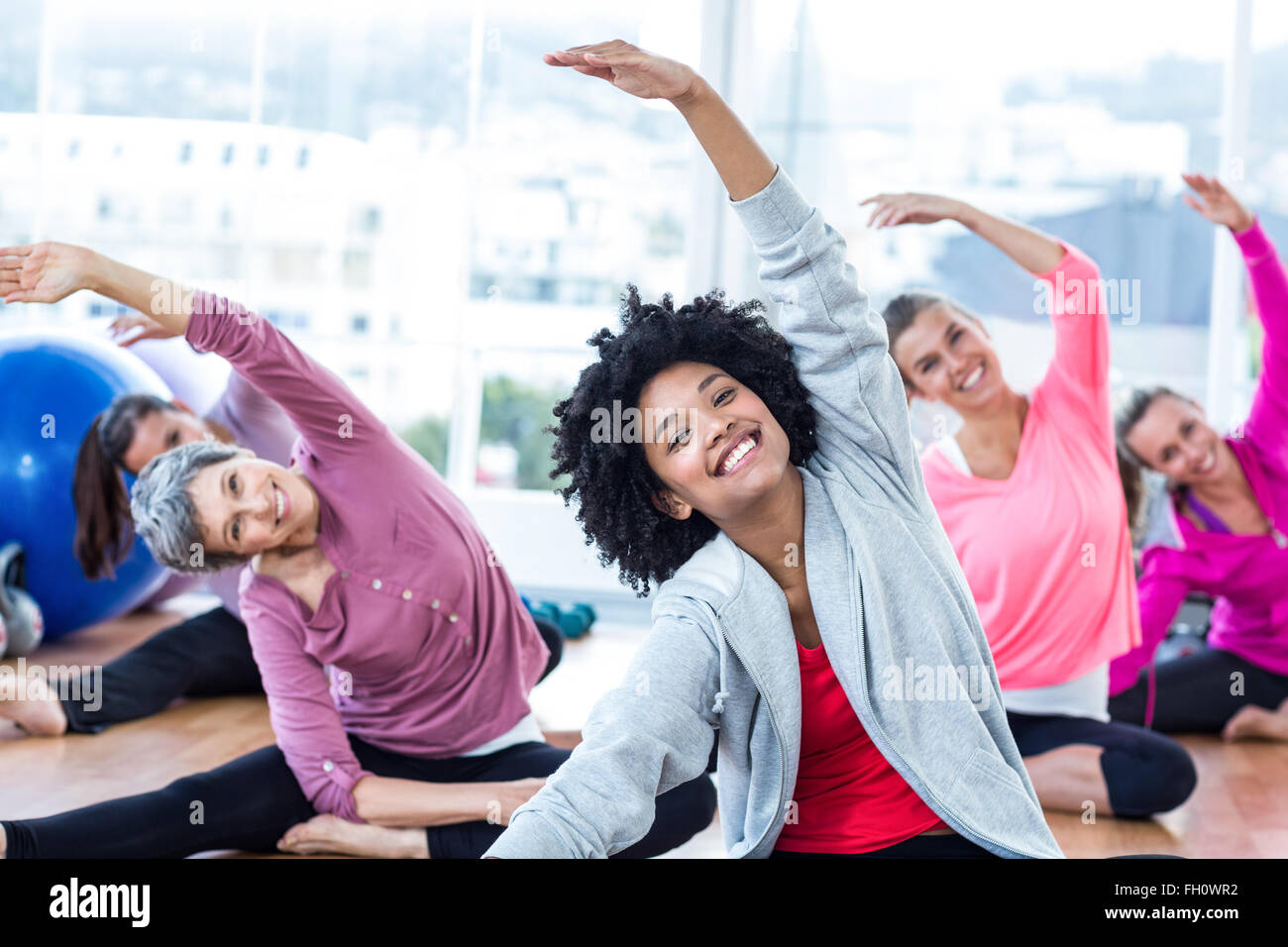 Cheerful women exercising with arms raised Stock Photo - Alamy