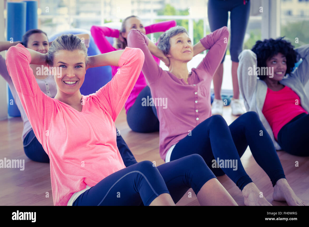 Portrait of woman doing sit ups with friends Stock Photo - Alamy
