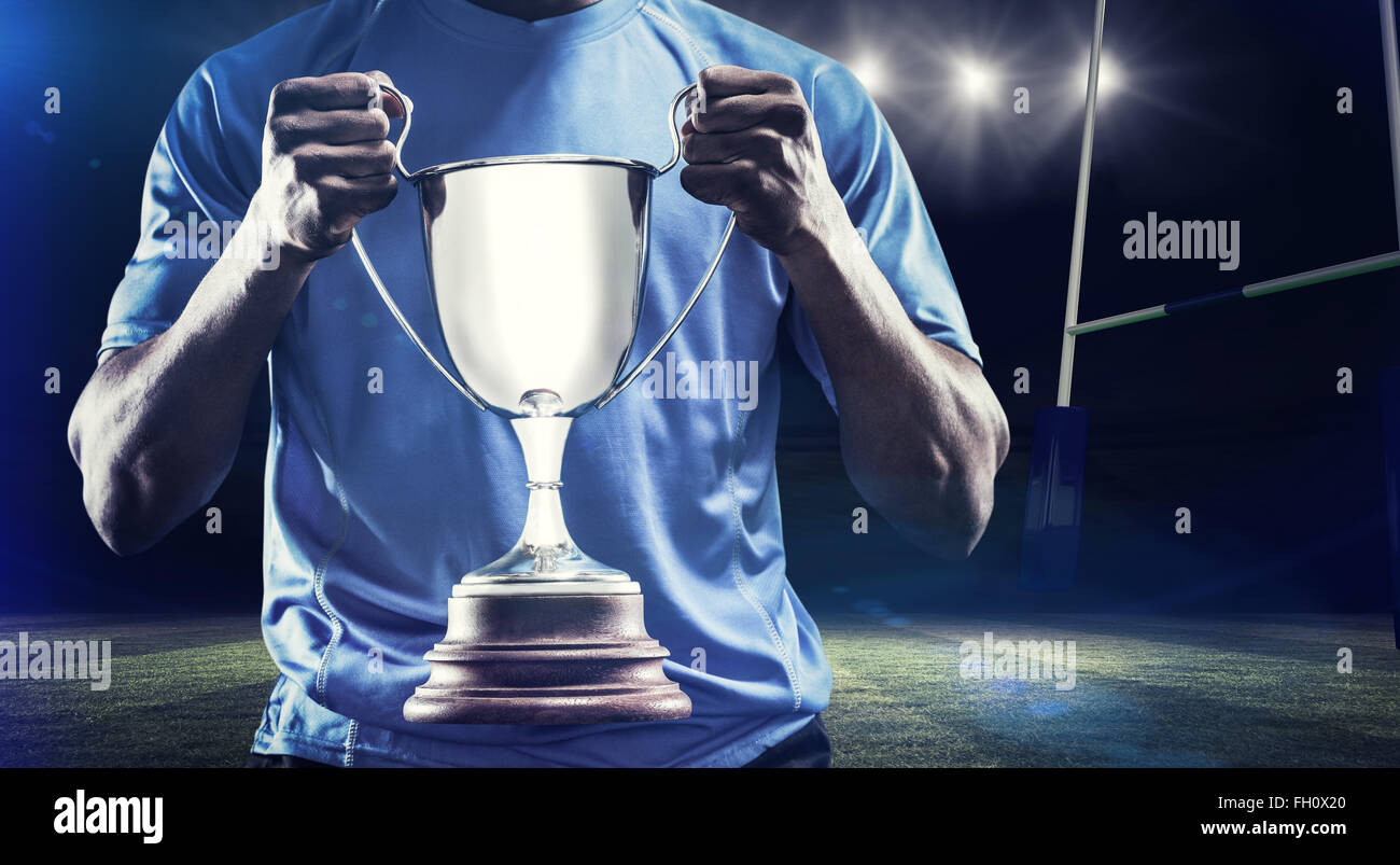 Composite image of mid section of sportsman holding trophy Stock Photo ...