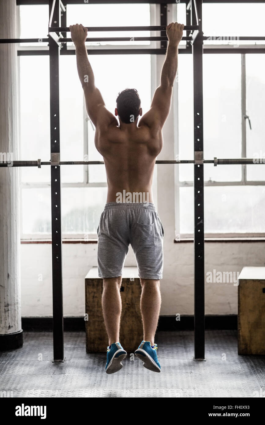 Muscular man lifting himself up and down Stock Photo - Alamy