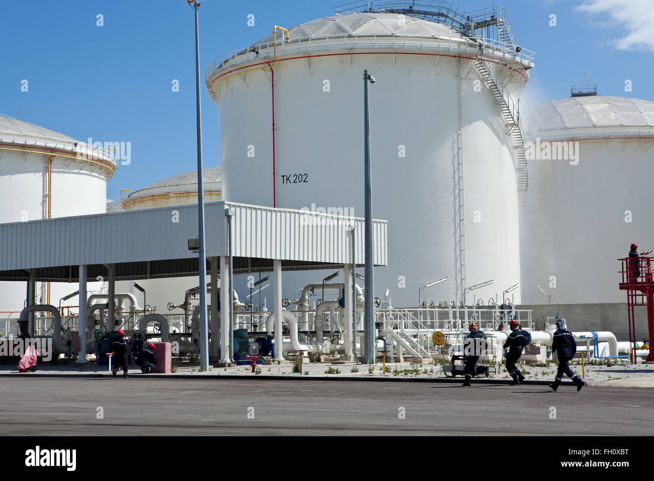 Firefighters applying foam to oil storage tank Stock Photo - Alamy