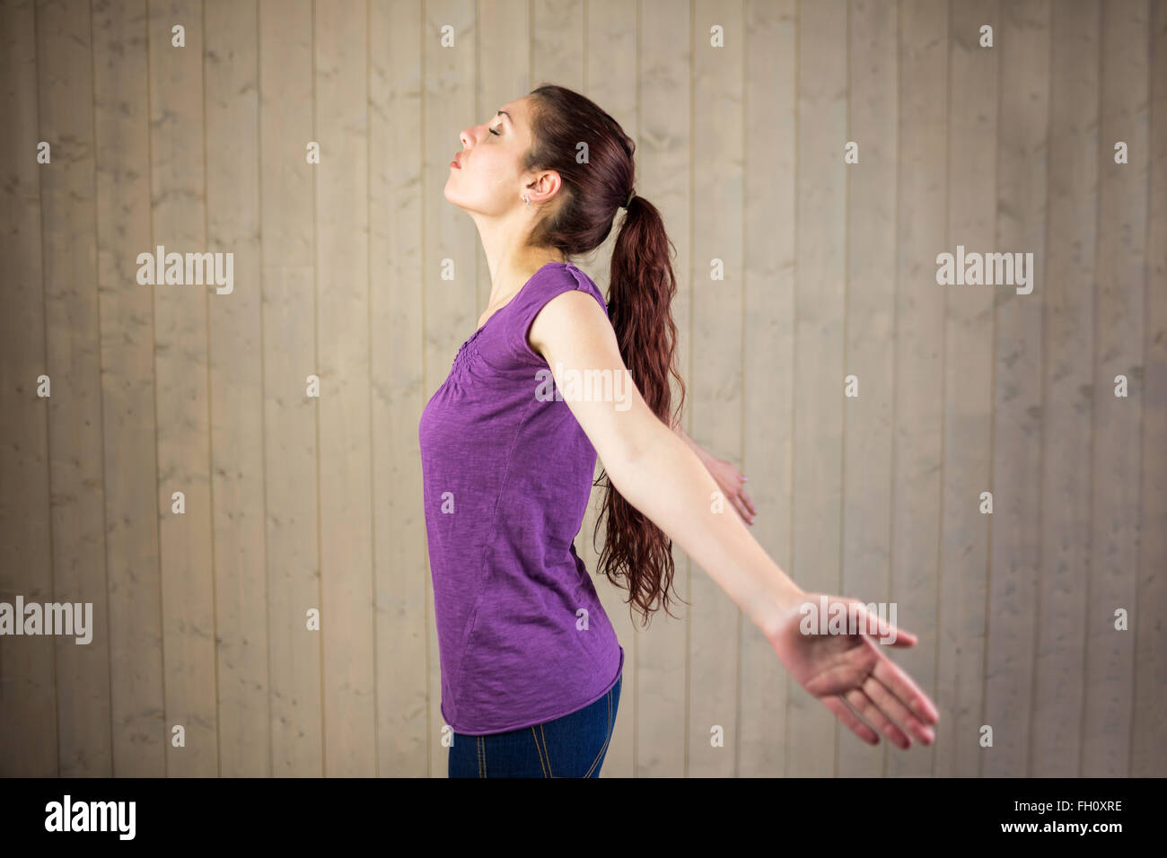 Side view of woman with arms outstretched and eyes closed Stock Photo ...