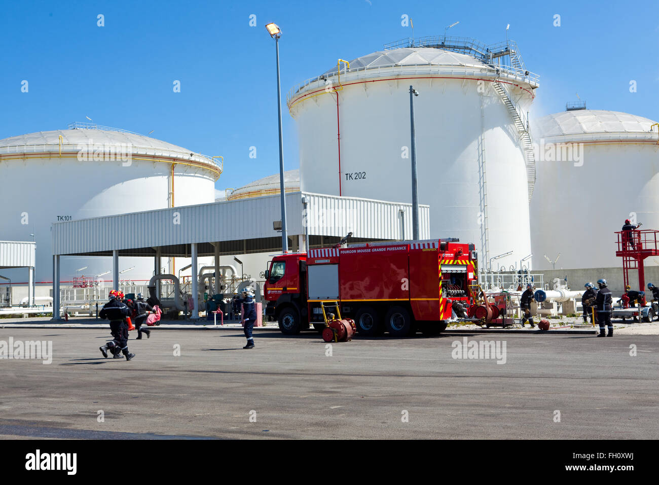 Firefighters applying foam to oil storage tank Stock Photo - Alamy
