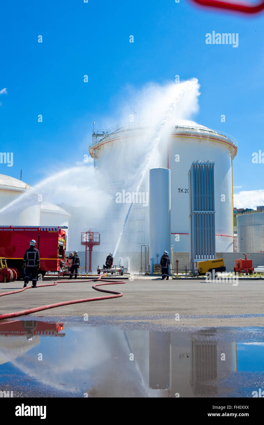 Firefighters applying foam to oil storage tank Stock Photo - Alamy