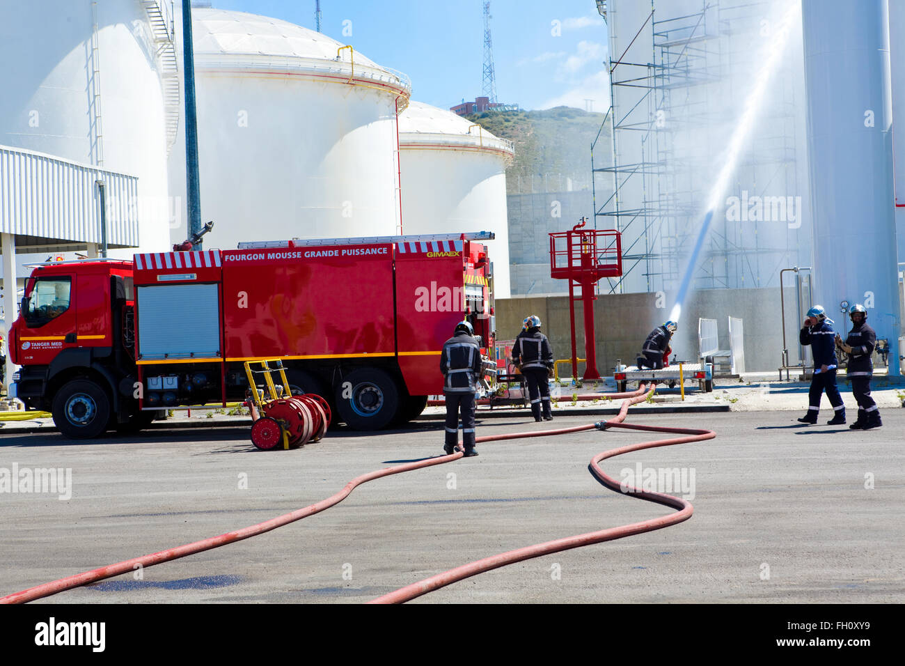 Firefighters applying foam to oil storage tank Stock Photo - Alamy