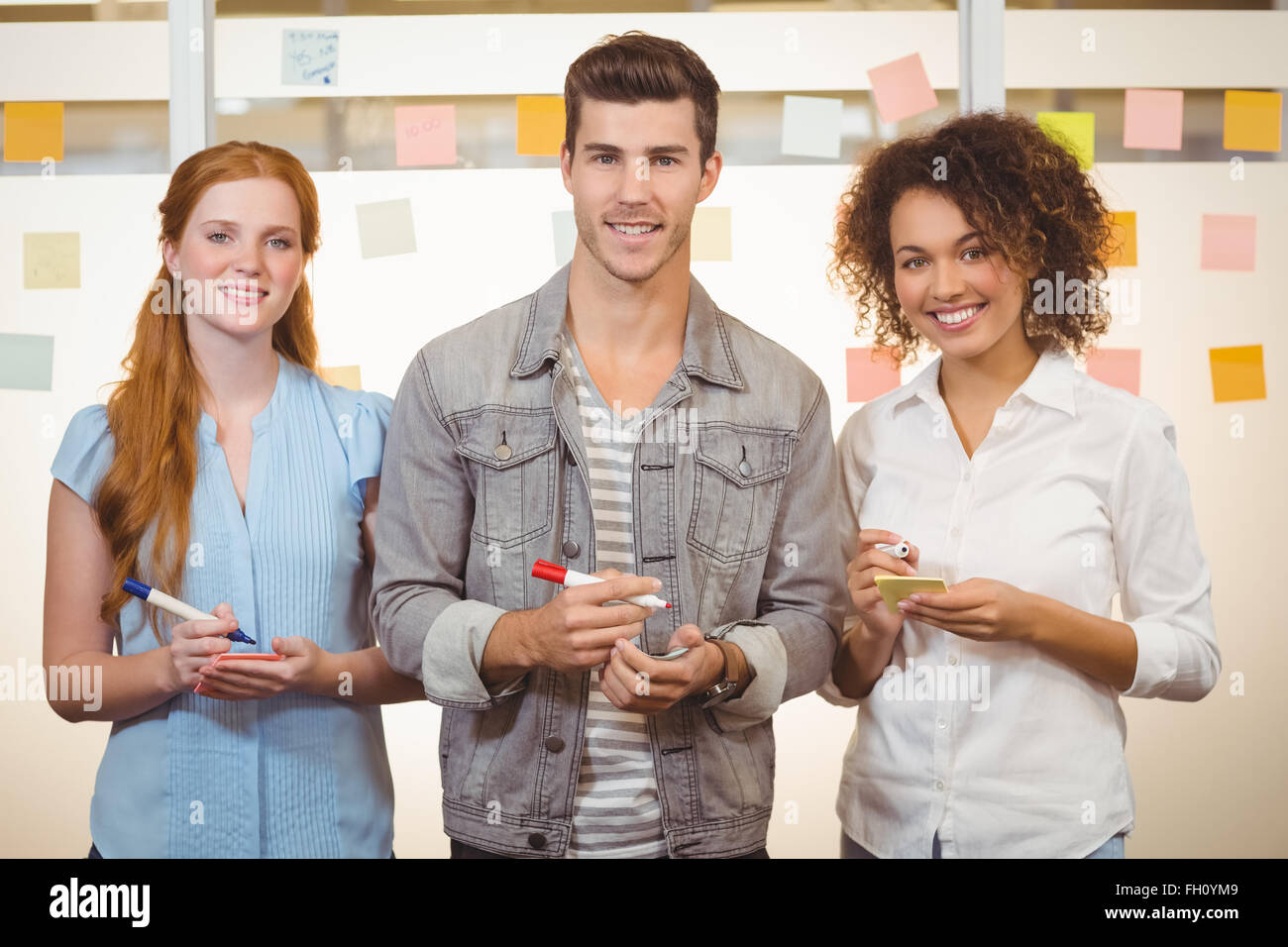 Smiling business people folding felt tip pens Stock Photo - Alamy