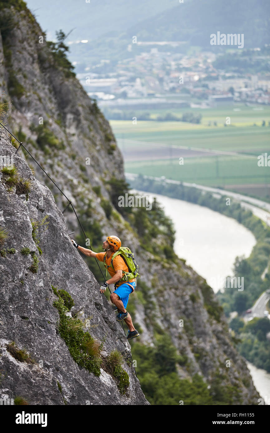 Mountaineer, climber with orange helmet climbing the via ferrata, Zirl ...