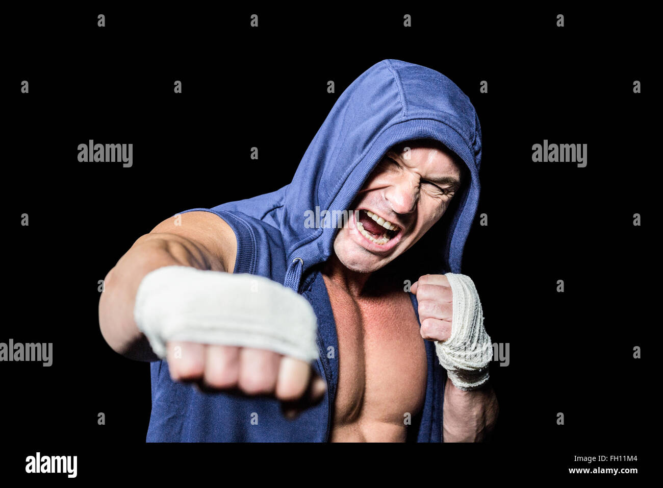 Aggressive fighter punching against black background Stock Photo - Alamy