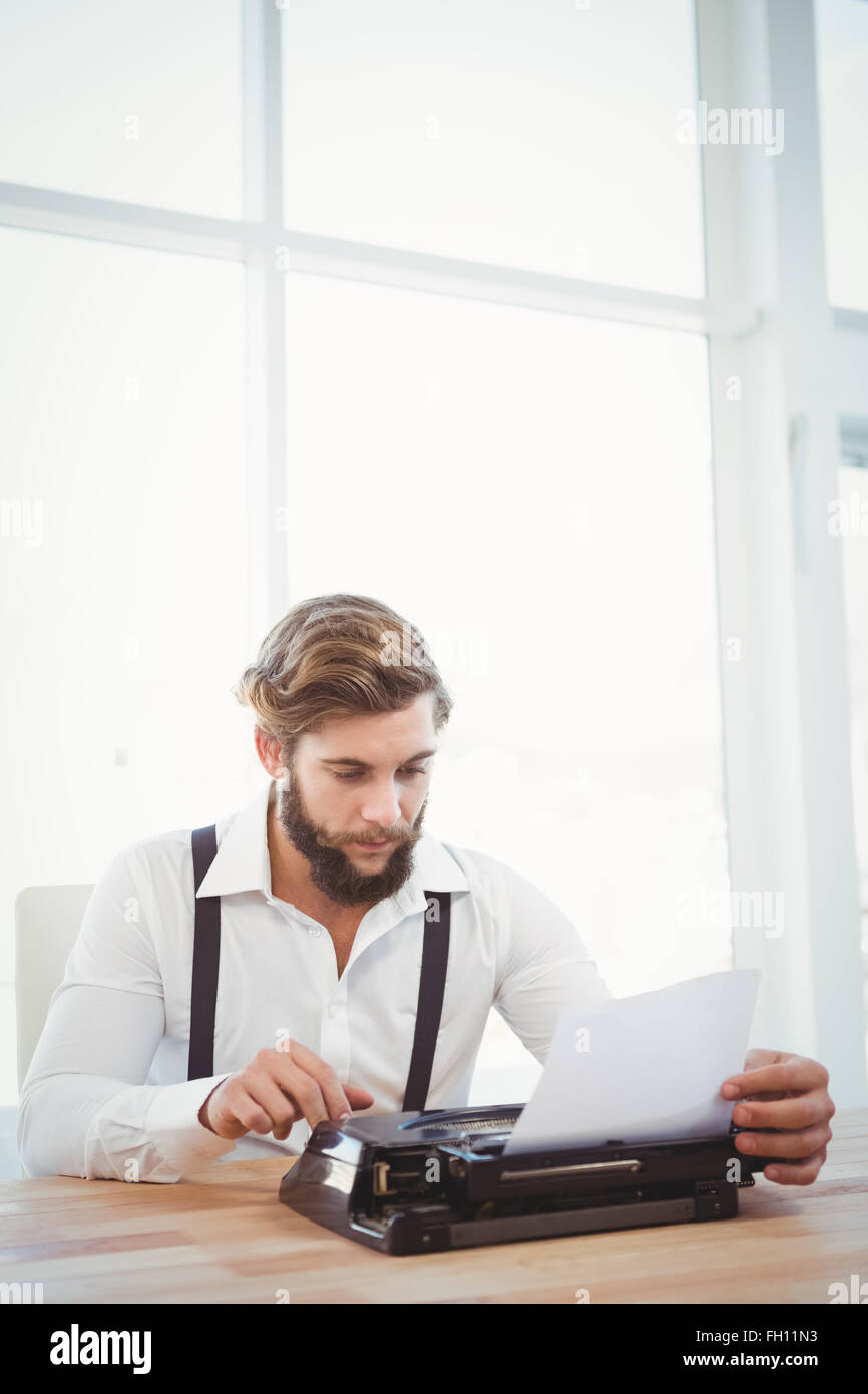 Hipster using typewriter at desk in office Stock Photo - Alamy