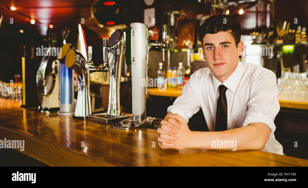 Confident male bartender sitting at bar counter Stock Photo - Alamy